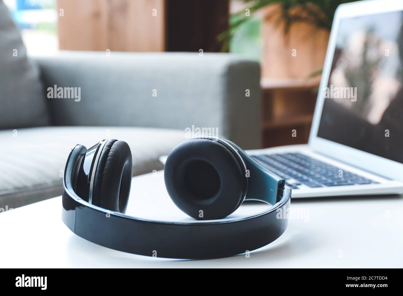 Modern headphones on table in room Stock Photo - Alamy