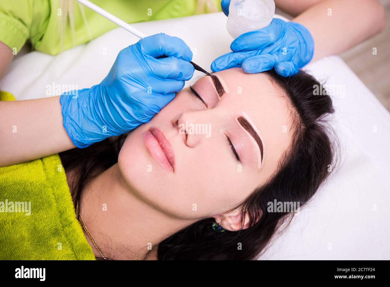 permanent eyebrow make up - beautician applying anesthesia and ...