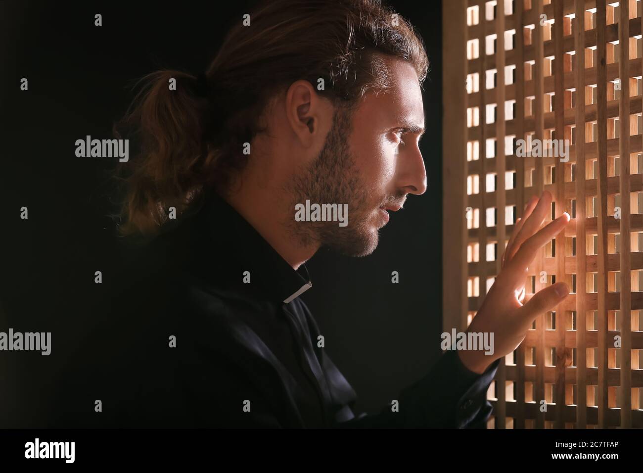 Male priest in confession booth Stock Photo - Alamy