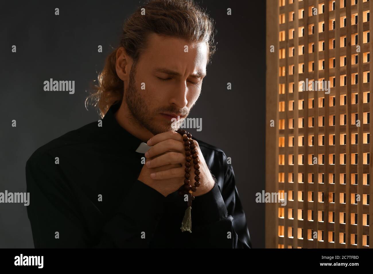 Male priest in confession booth Stock Photo - Alamy