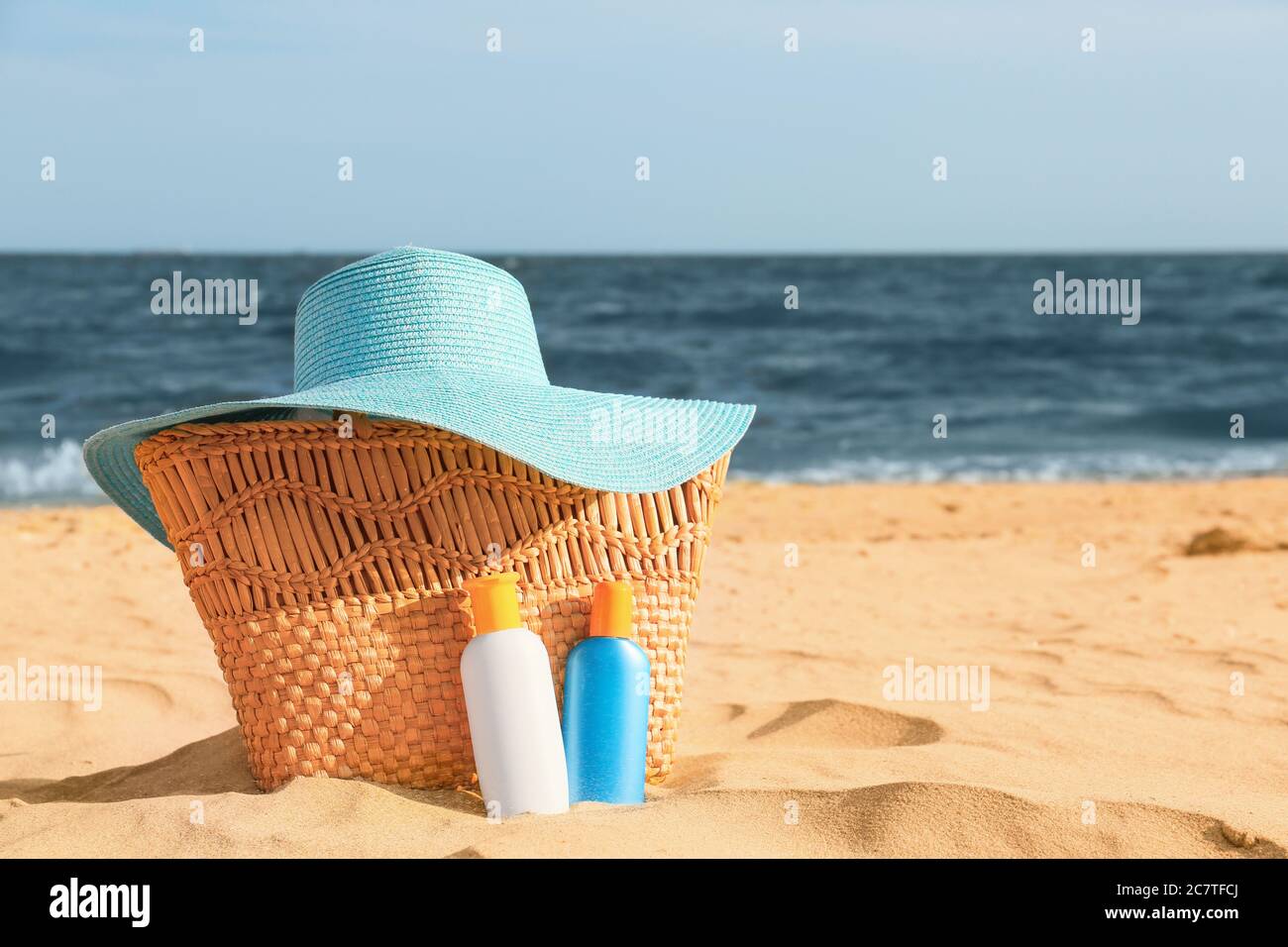 Bag with sunscreen cream and hat on beach Stock Photo - Alamy