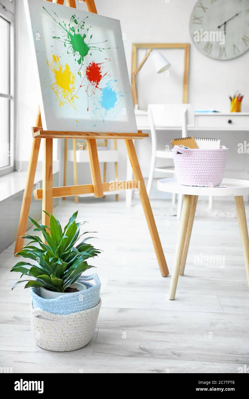 Interior of room with easel and painting supplies Stock Photo - Alamy