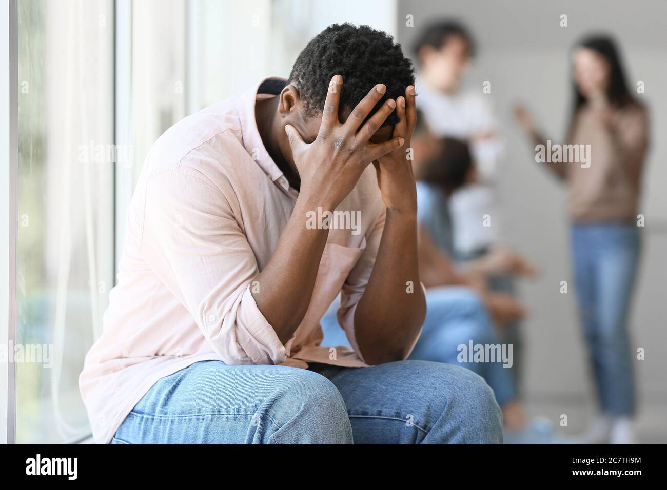 Lonely African-American man near window in hall. Stop racism Stock ...