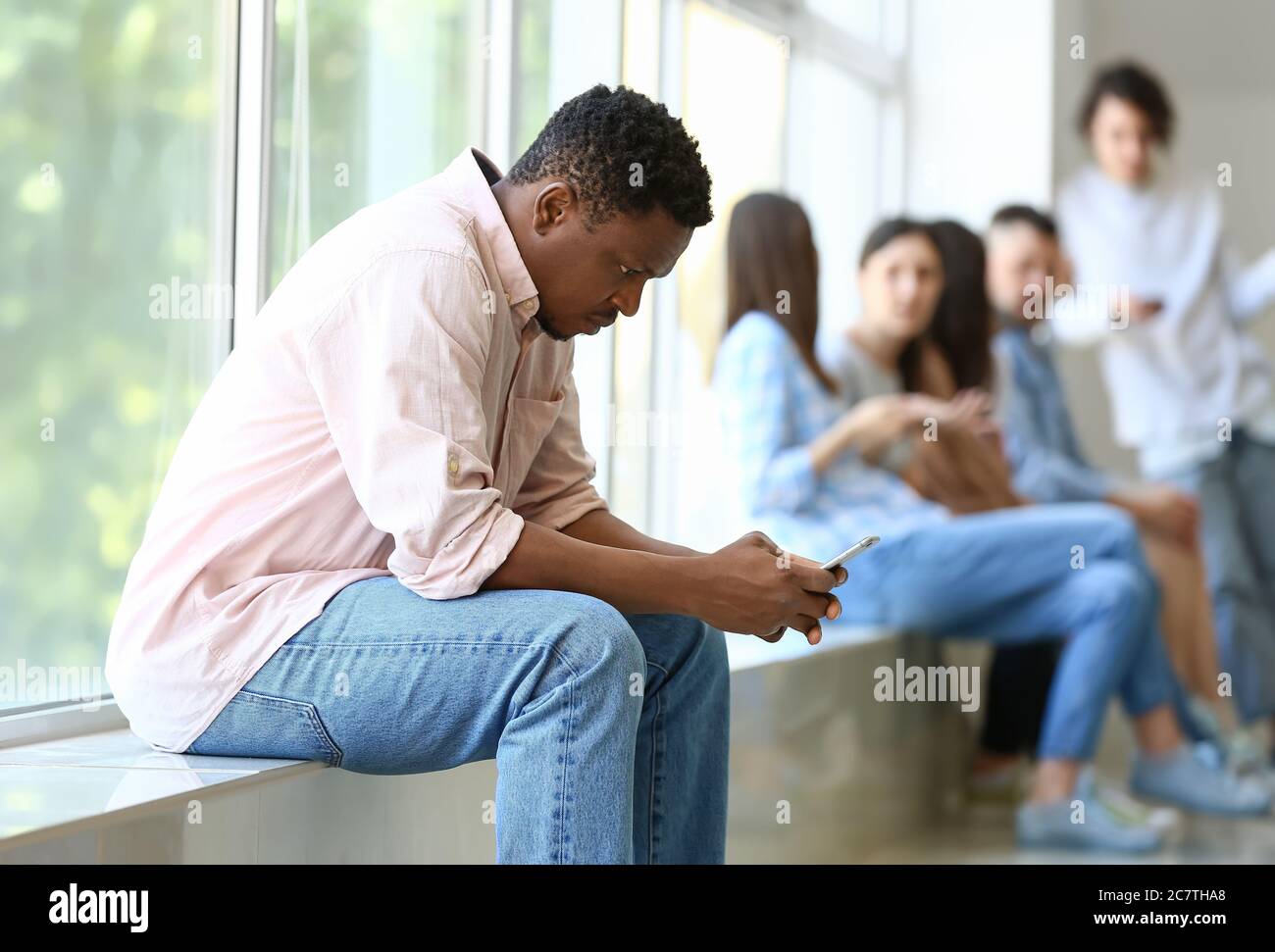 Lonely African-American man near window in hall. Stop racism Stock ...