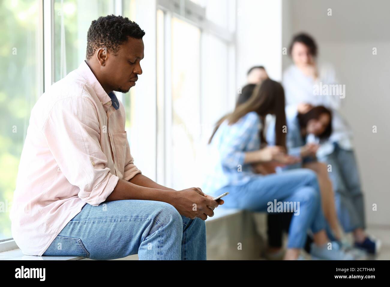 Lonely African-American man near window in hall. Stop racism Stock ...