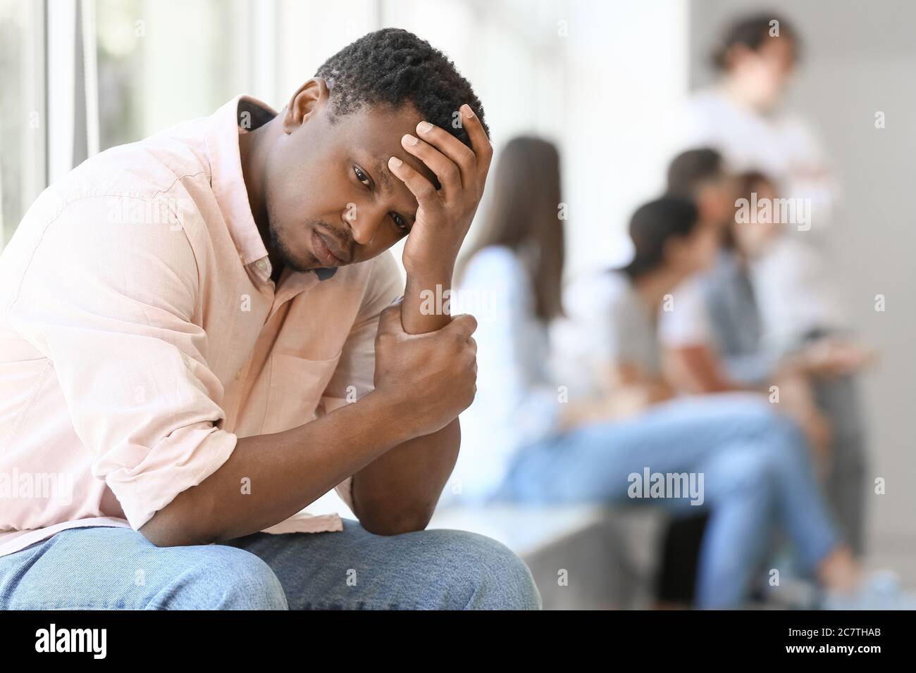 Lonely African-American man near window in hall. Stop racism Stock ...