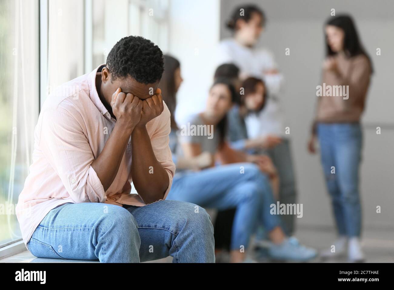 Lonely African-American man near window in hall. Stop racism Stock ...