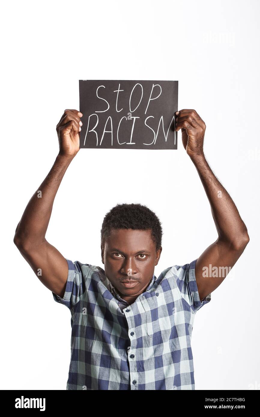 Sad African-American man with poster on white background. Stop racism ...
