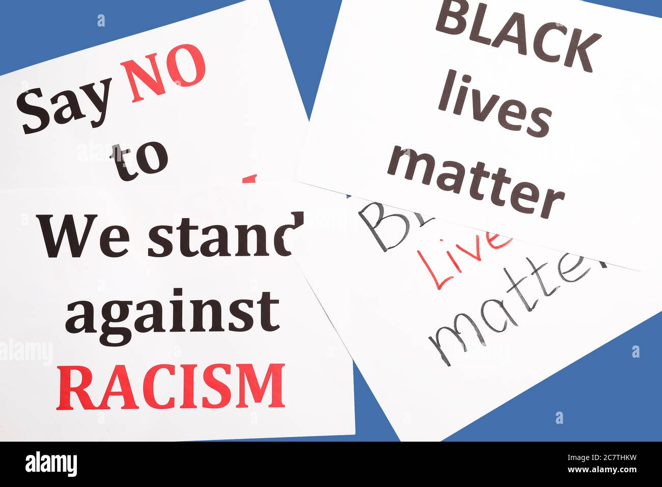Different placards on color background. Stop racism Stock Photo - Alamy