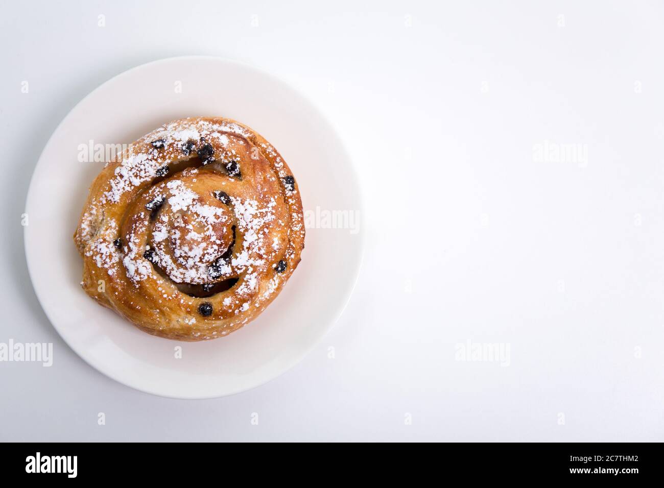 top view of sweet bun with raisins over white background Stock Photo ...