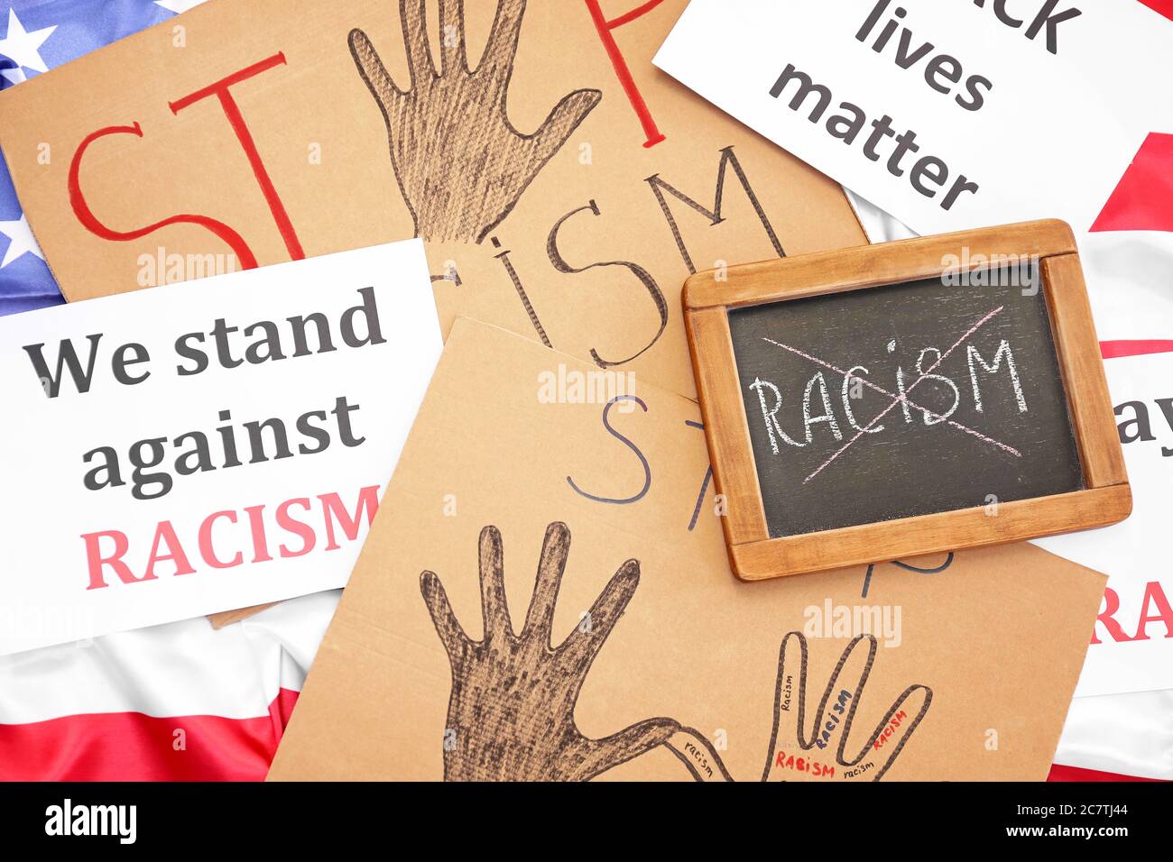 Chalkboard with crossed out word RACISM and placards Stock Photo - Alamy