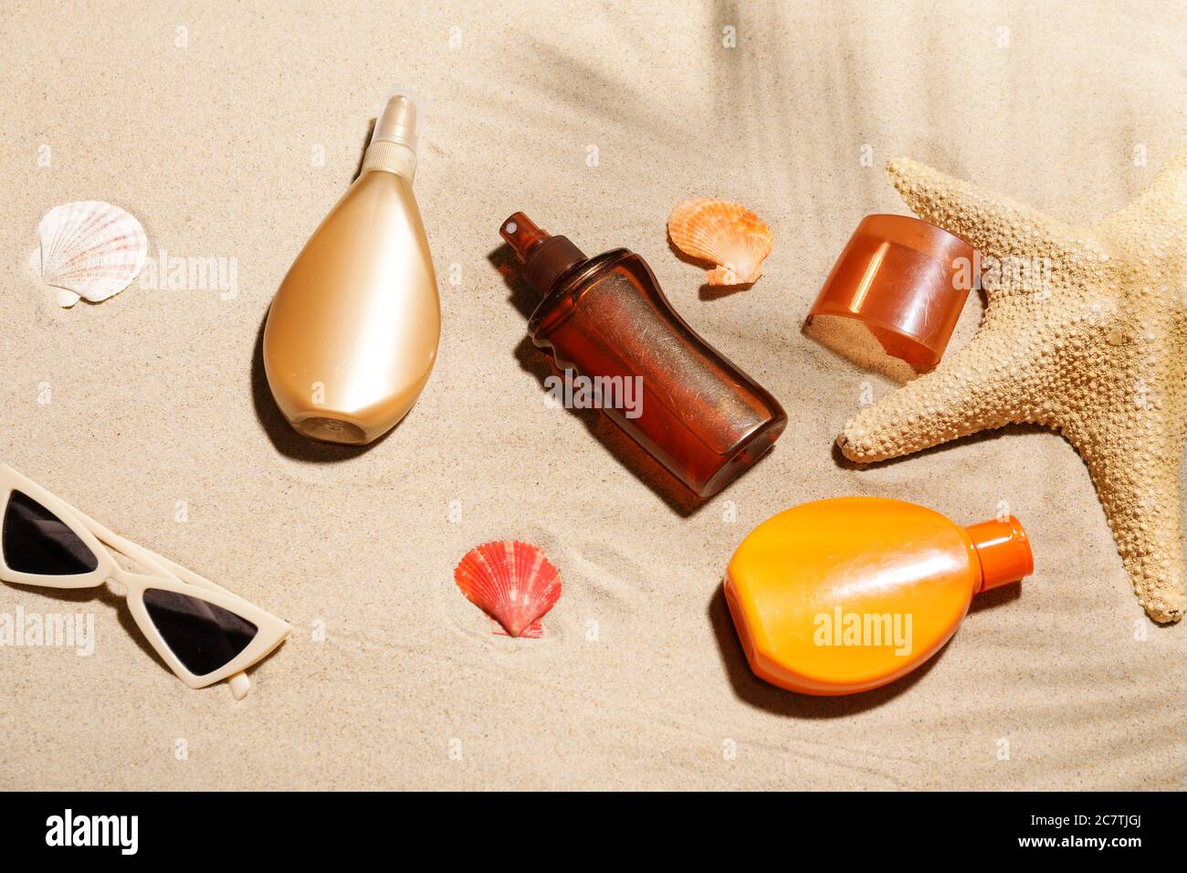 Composition with bottles of sunscreen on sand Stock Photo - Alamy