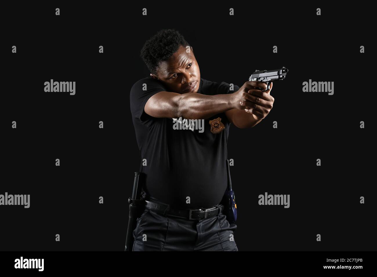 Aggressive African-American police officer with gun on dark background ...