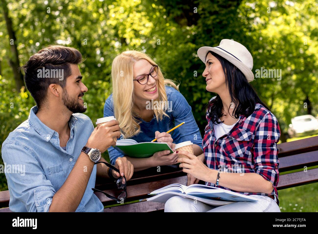 Students having fun while doing homework together in campus park Stock ...