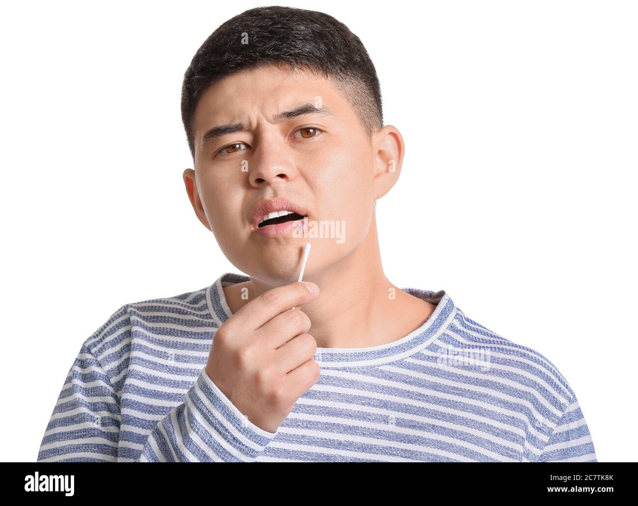 Asian man with cold sore applying ointment on his lips against white background Stock Photo - Alamy