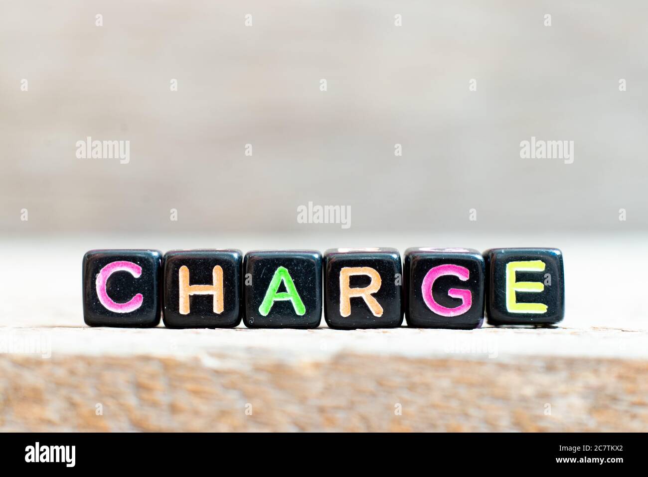 Black bead with color letter in word charge on wood background Stock ...