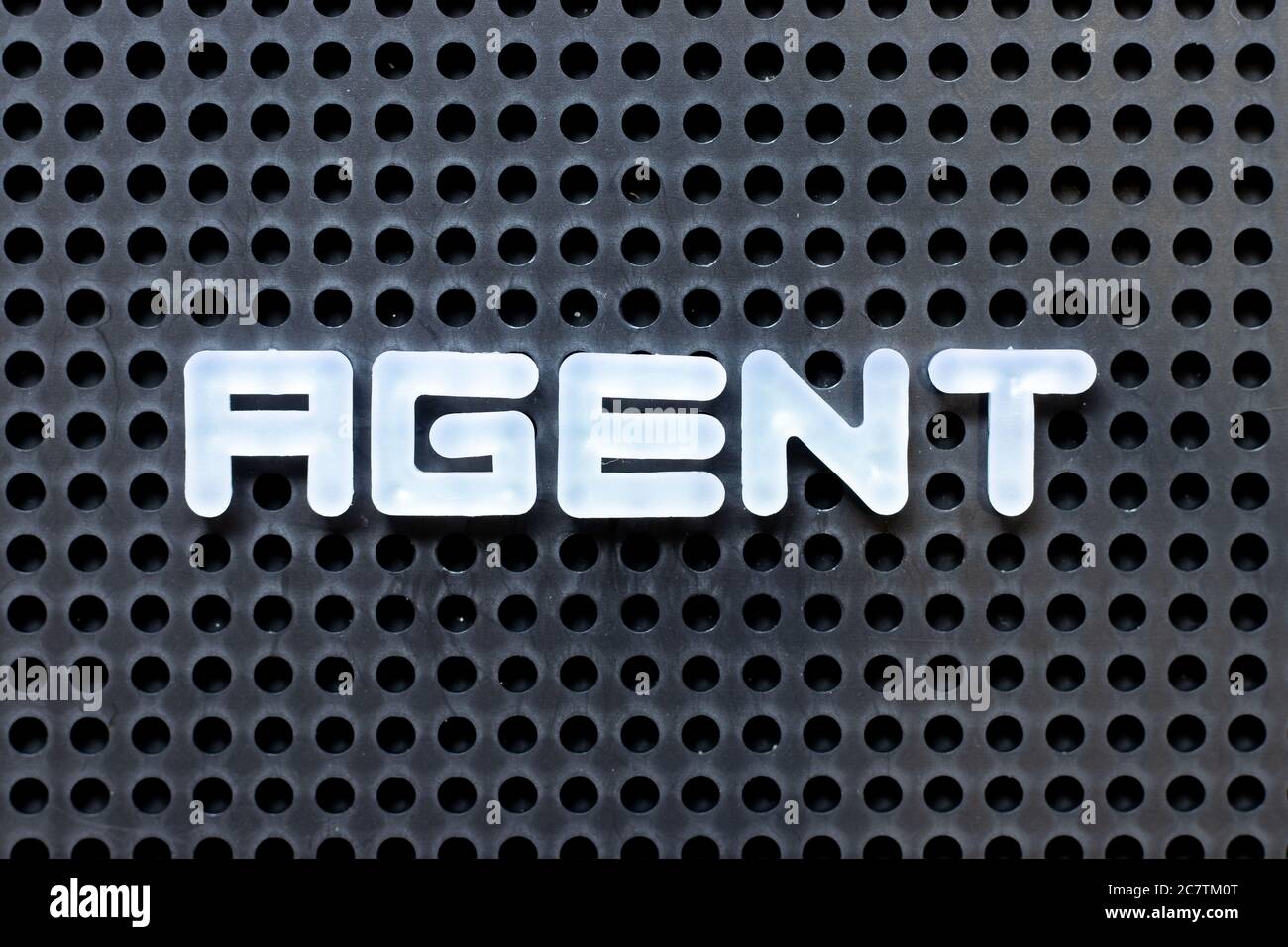 White color alphabet with word agent on black pegboard background Stock ...