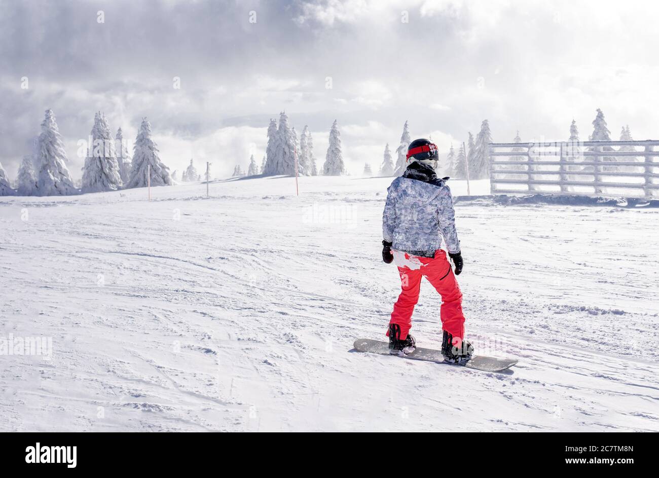 Back view of a snowboarder riding in the resort on a gloomy day Stock ...