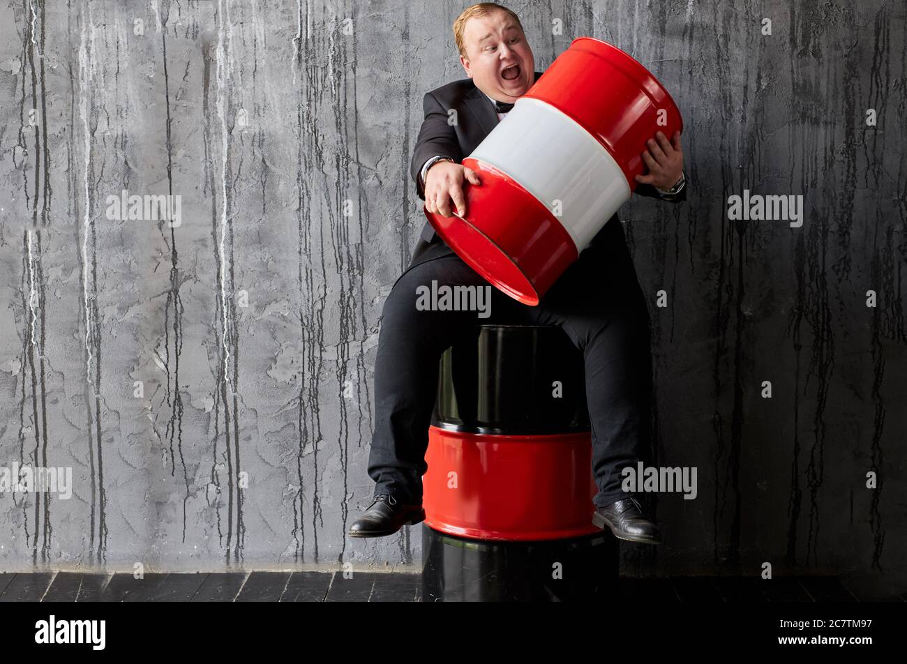 happy young fat oilman hugs barrel, his company holds its brand on ...