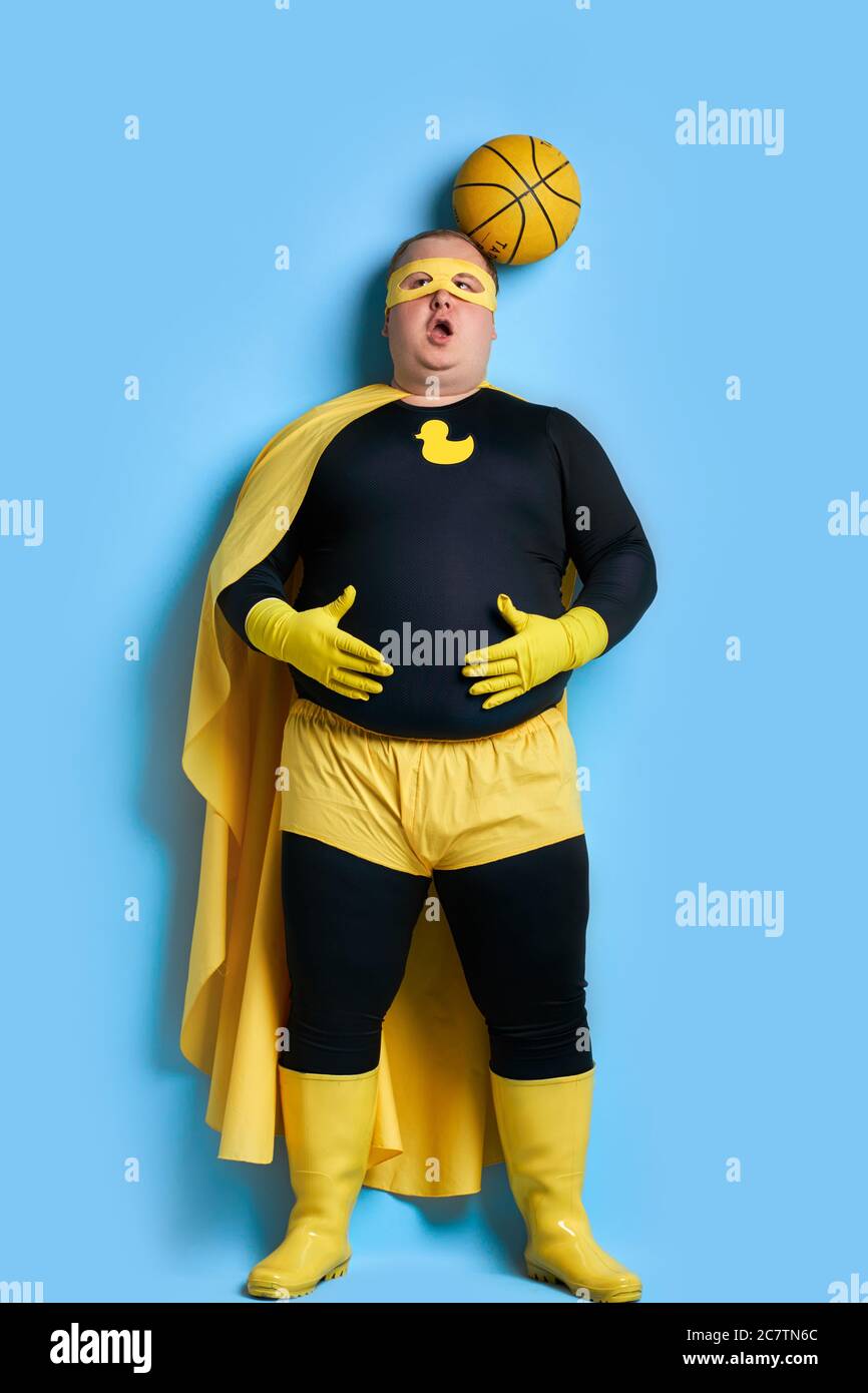 portrait of sportive funny fat superhero with ball on head isolated ...