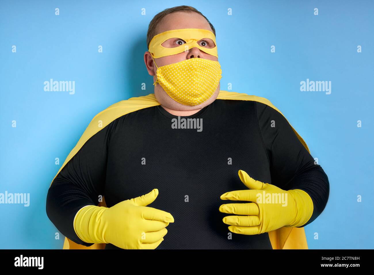 young caucasian fat cleaning man in costume of superhero and in mask ...