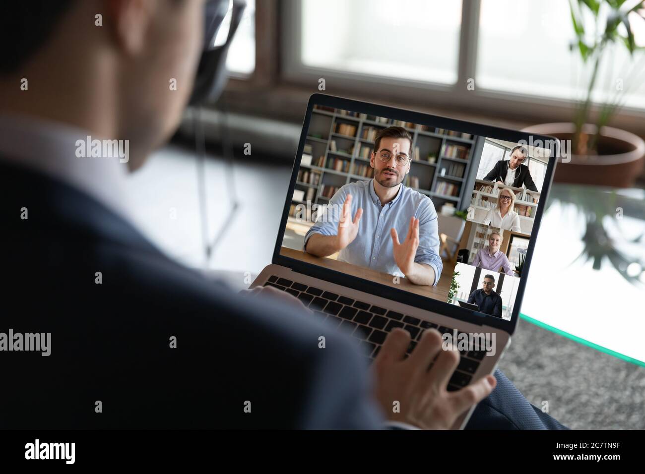 Back view of businessman talk on video call with colleagues Stock Photo ...