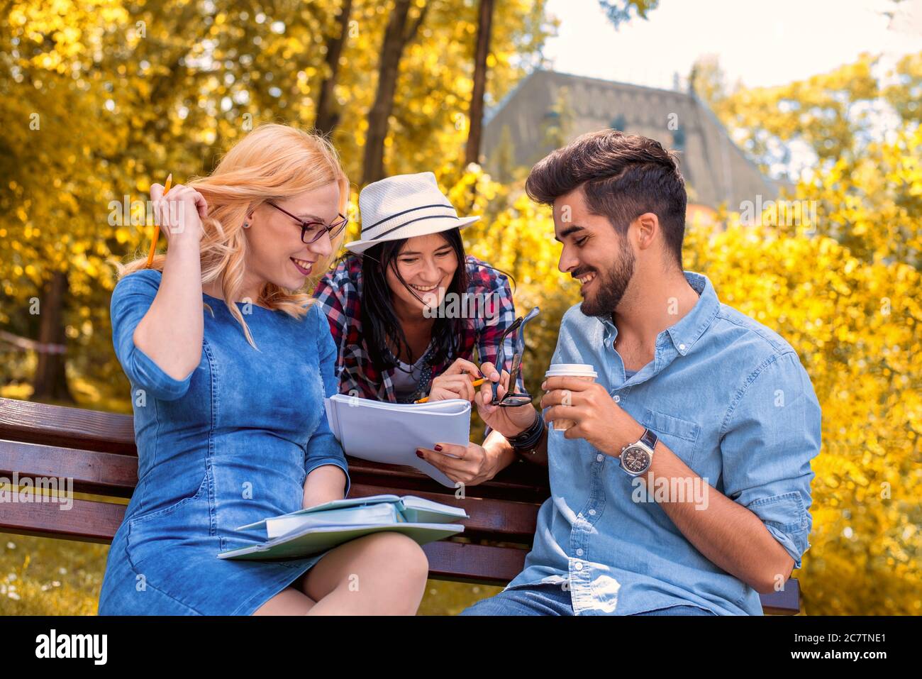 Group of young Caucasian friends looking into papers and smiling Stock ...