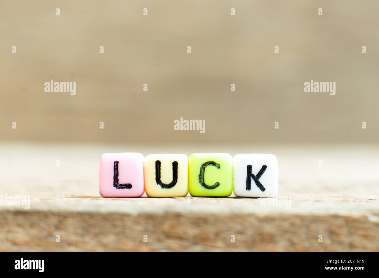 Colorful bead with black letter in word luck on wood background Stock ...