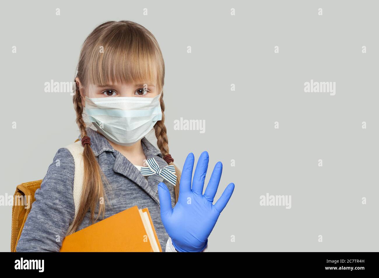 Little child girl in medical protective face mask showing stop gesture ...