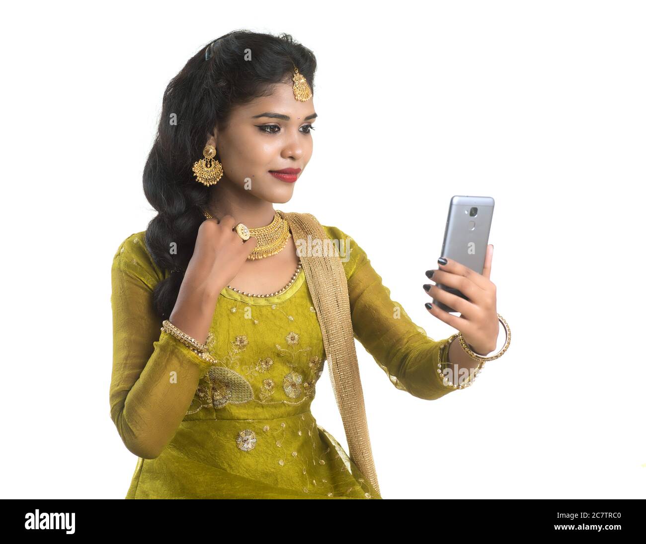 Young Indian traditional girl using a mobile phone or smartphone ...