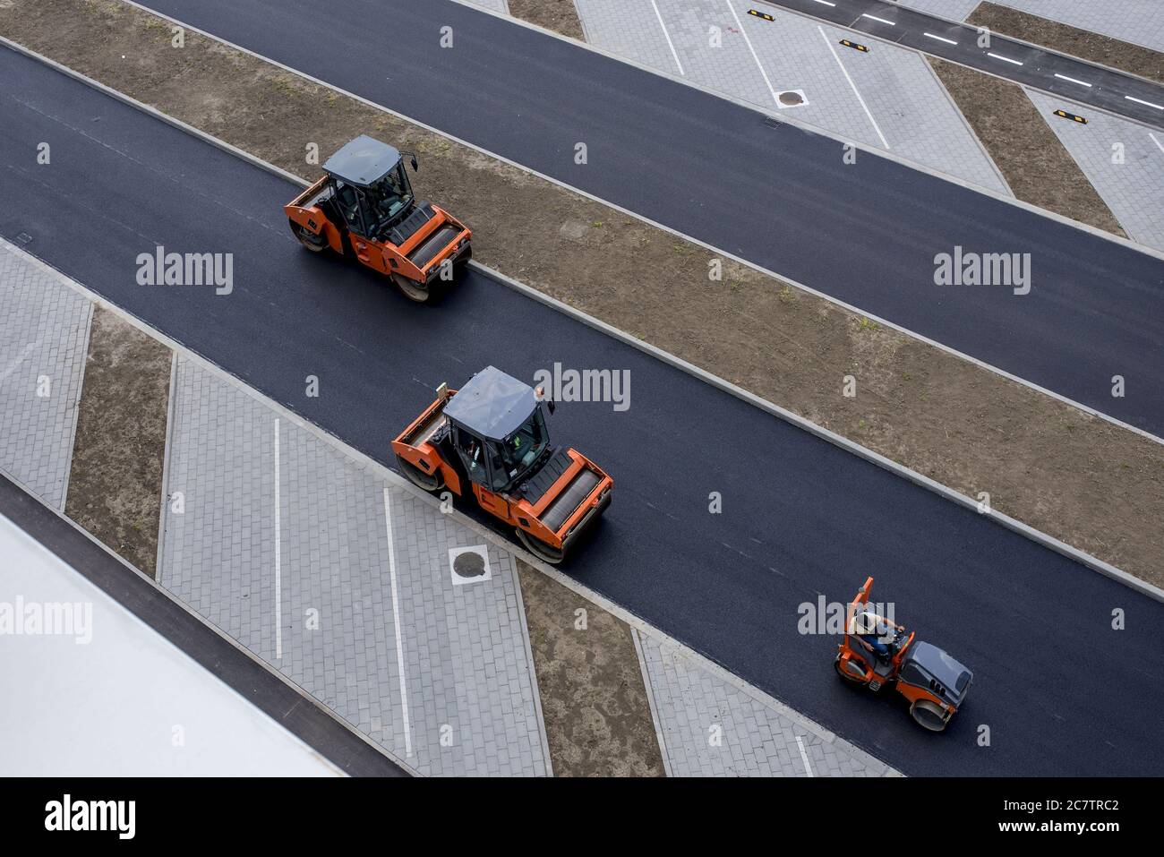 Aerial view of orange vibratory asphalt roller compactor on a new ...
