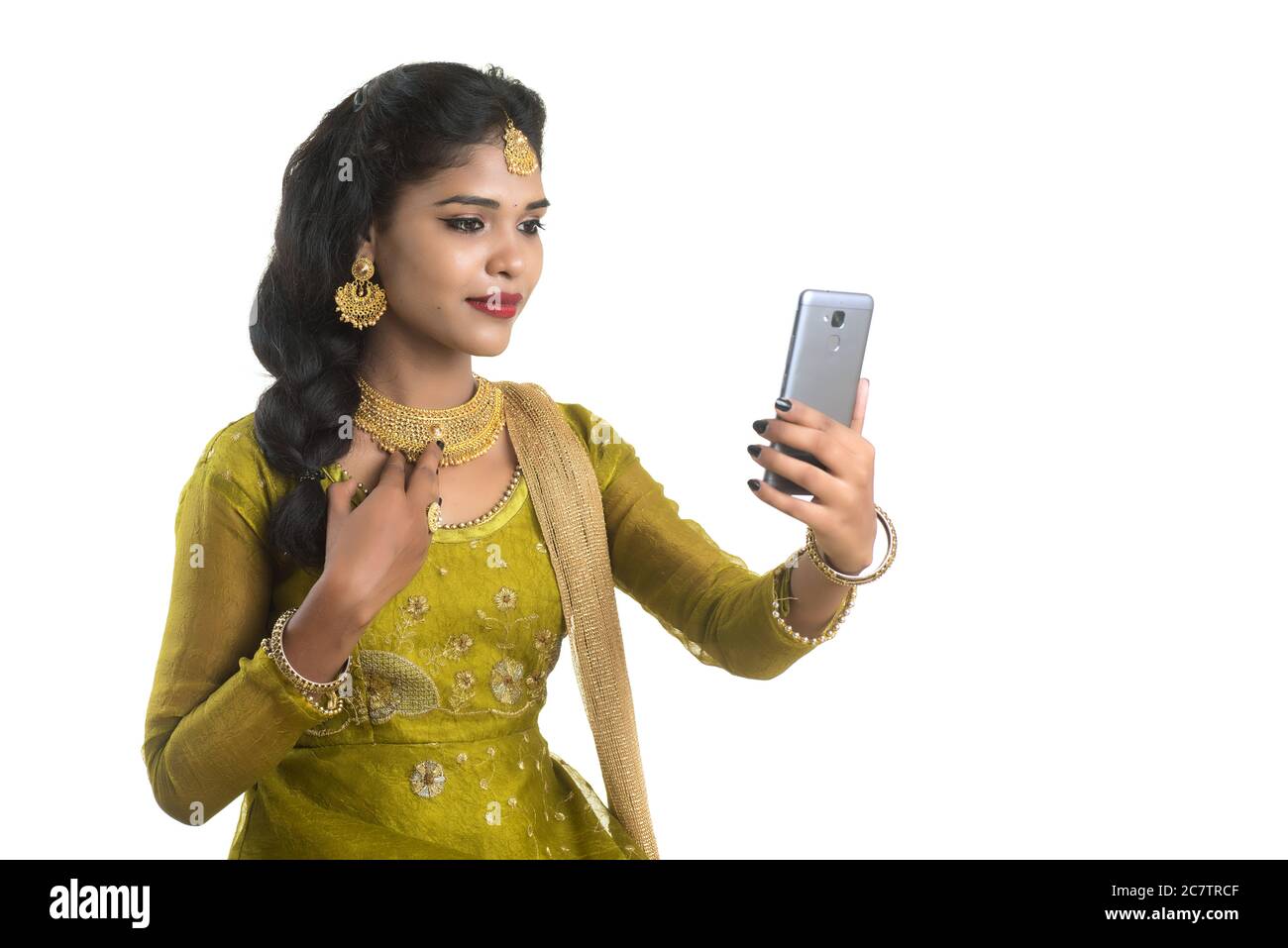 Young Indian traditional girl using a mobile phone or smartphone ...