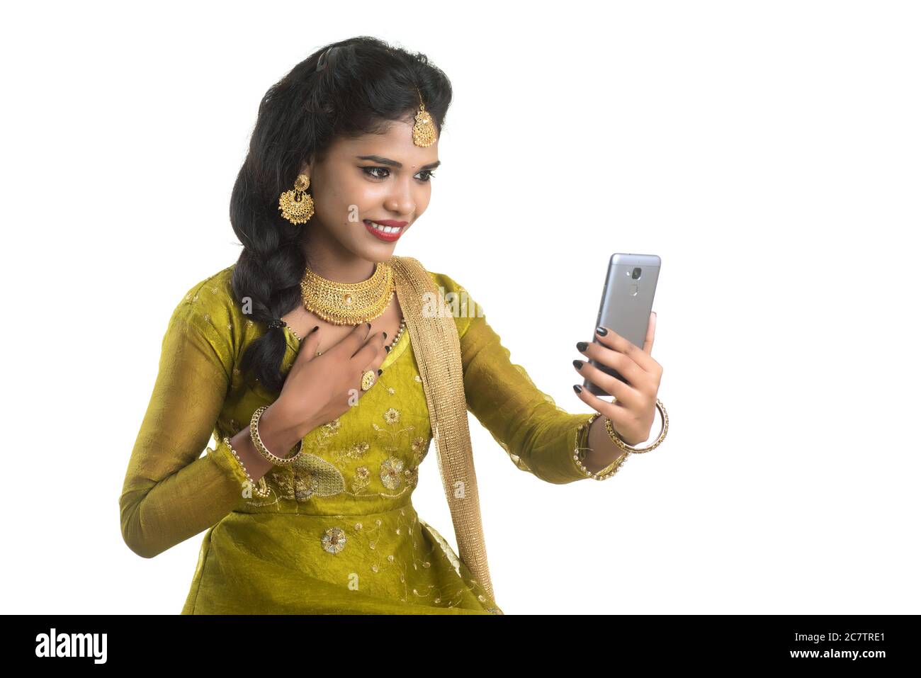 Young Indian traditional girl using a mobile phone or smartphone ...