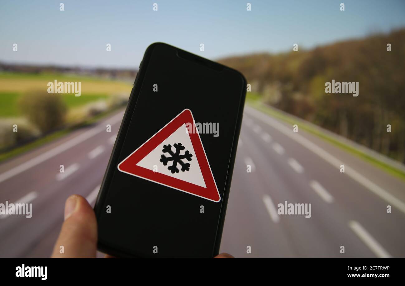 View on hand holding mobile phone with yellow triangle international ...