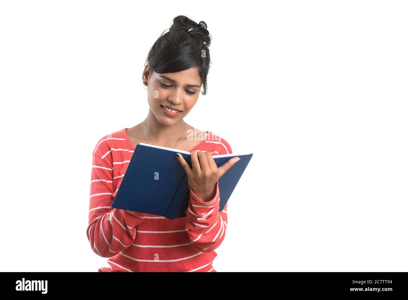 Pretty young girl holding book and posing on white background Stock ...