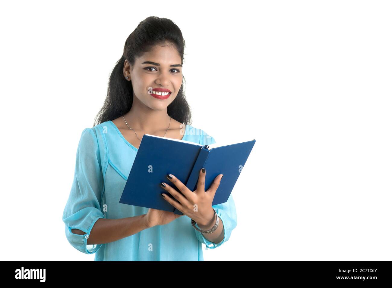 Pretty young girl holding book and posing on white background Stock ...