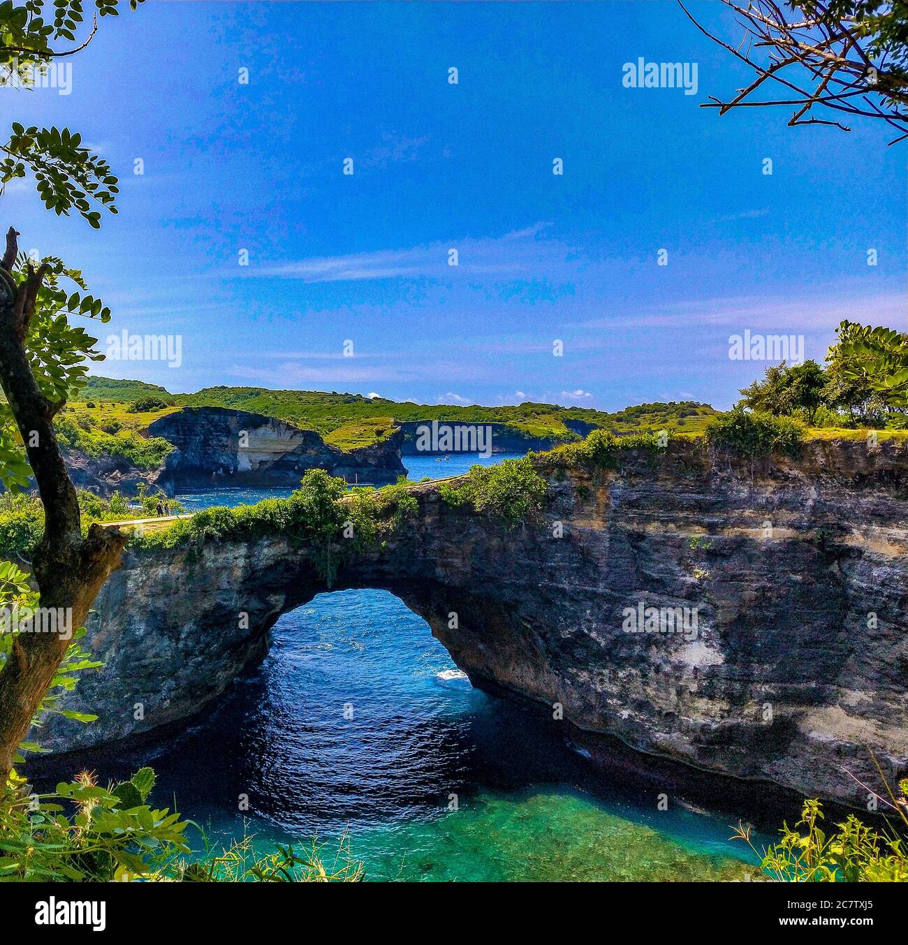 Rock coastline. Stone arch over the sea. Broken beach, Nusa Penida ...