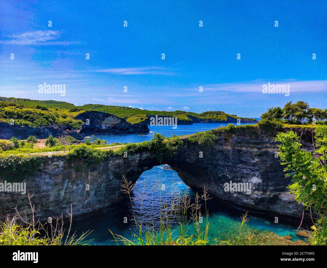 Rock coastline. Stone arch over the sea. Broken beach, Nusa Penida ...