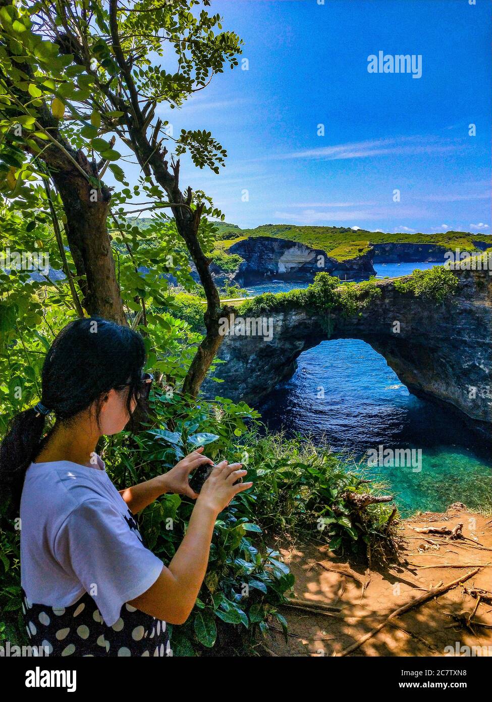 Rock coastline. Stone arch over the sea. Broken beach, Nusa Penida ...