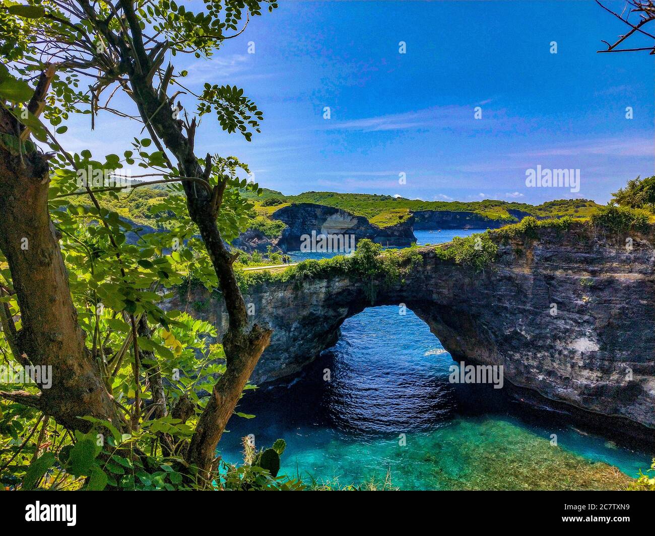 Rock coastline. Stone arch over the sea. Broken beach, Nusa Penida ...