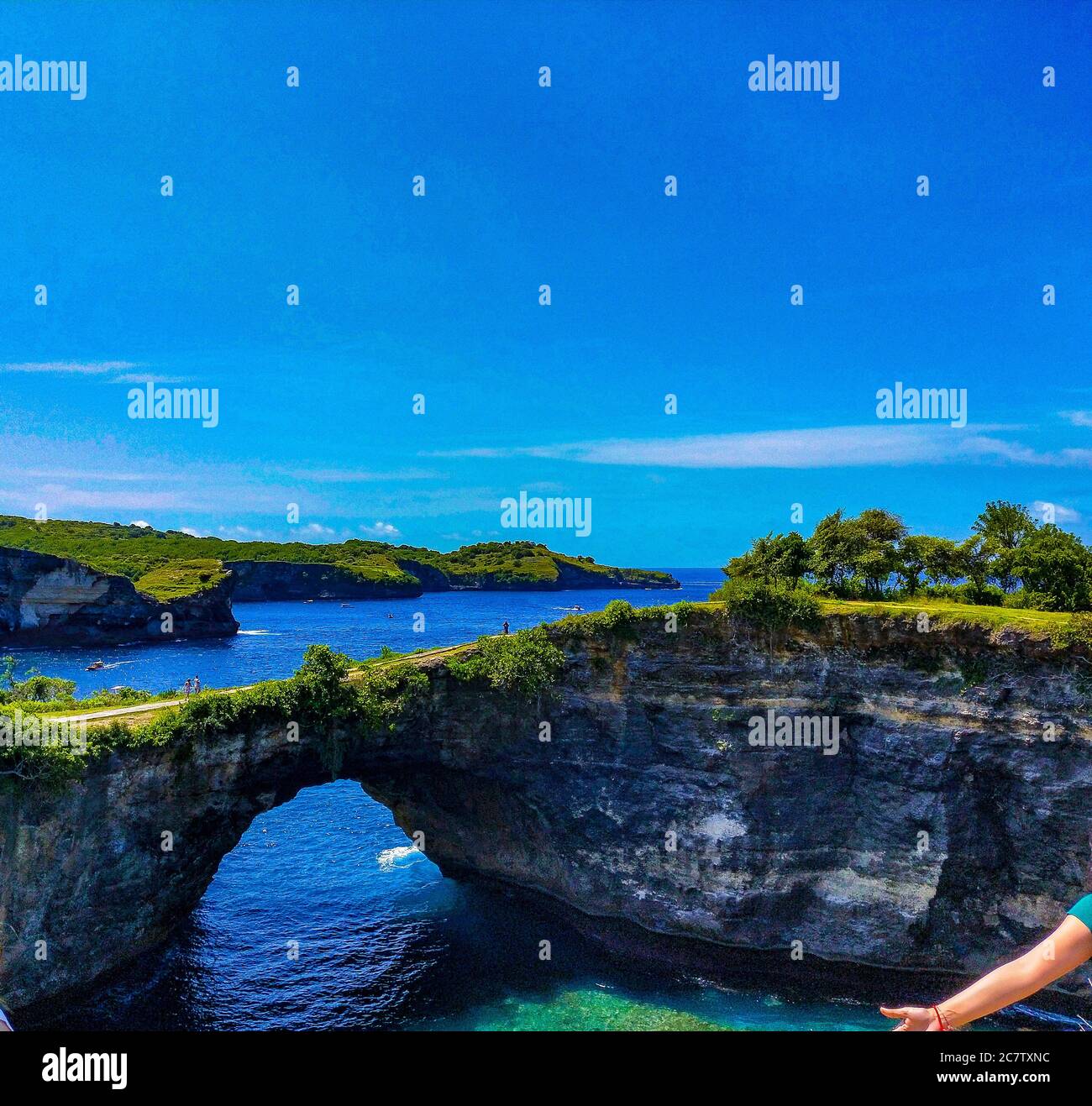 Rock coastline. Stone arch over the sea. Broken beach, Nusa Penida ...
