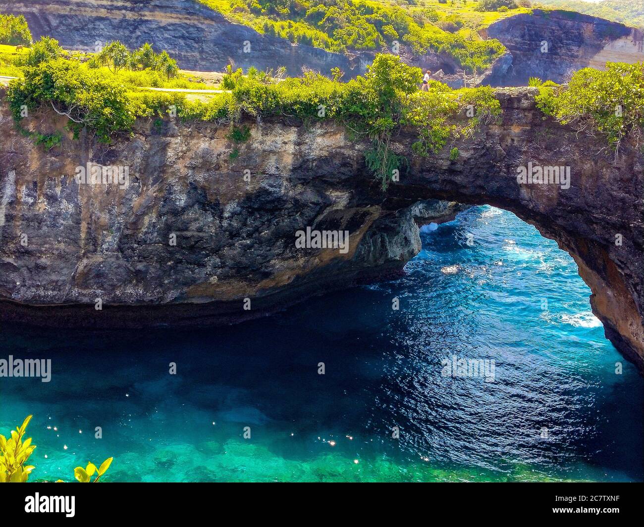 Rock coastline. Stone arch over the sea. Broken beach, Nusa Penida ...