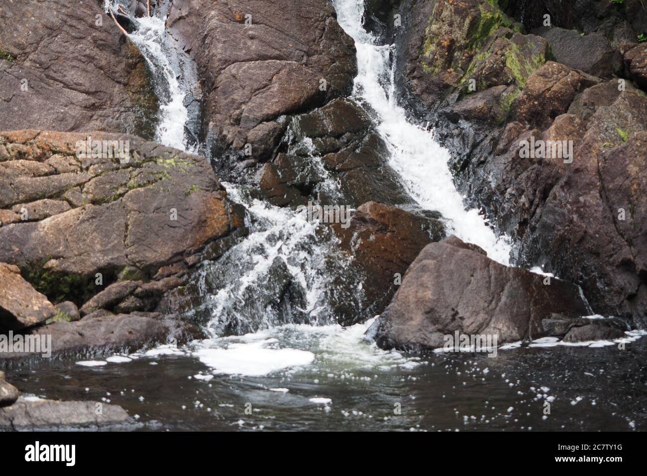 Waterfall falling into a lake with stones covered with moss in Halifax ...