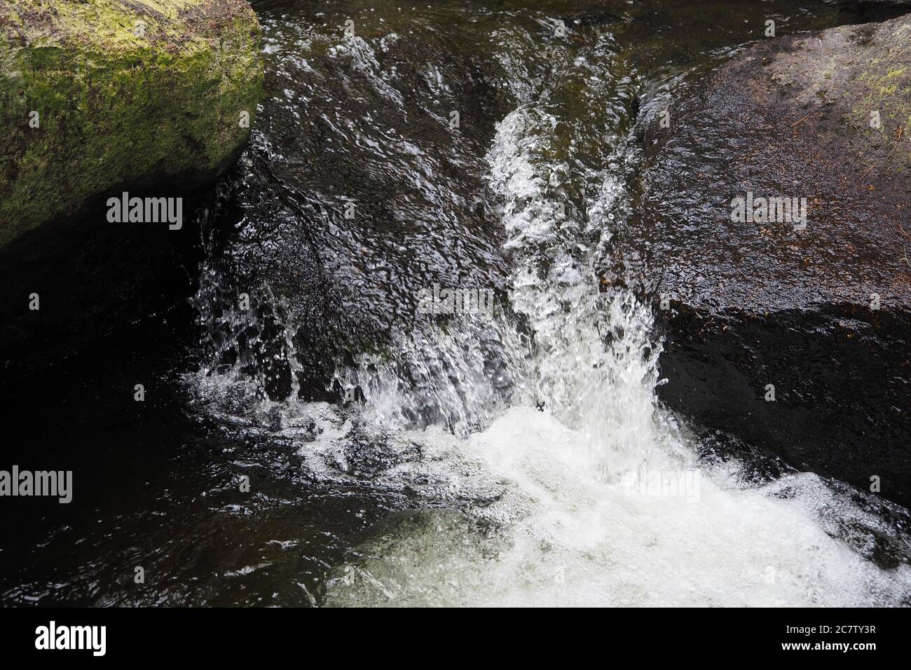 Waterfall falling into a lake with stones covered with moss in Halifax ...