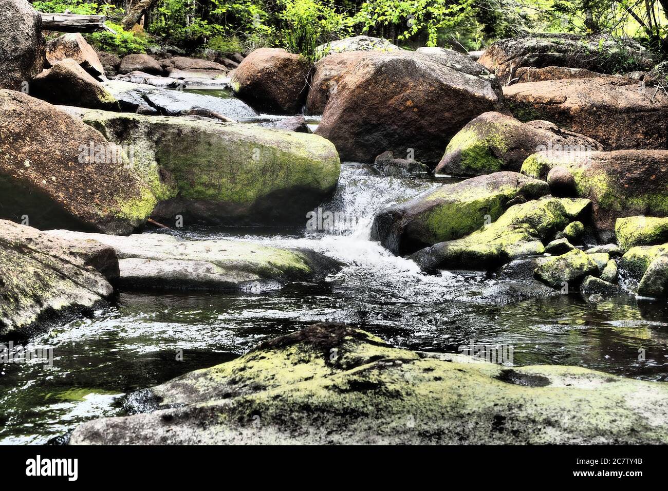 Waterfall falling into a lake with stones covered with moss in Halifax ...