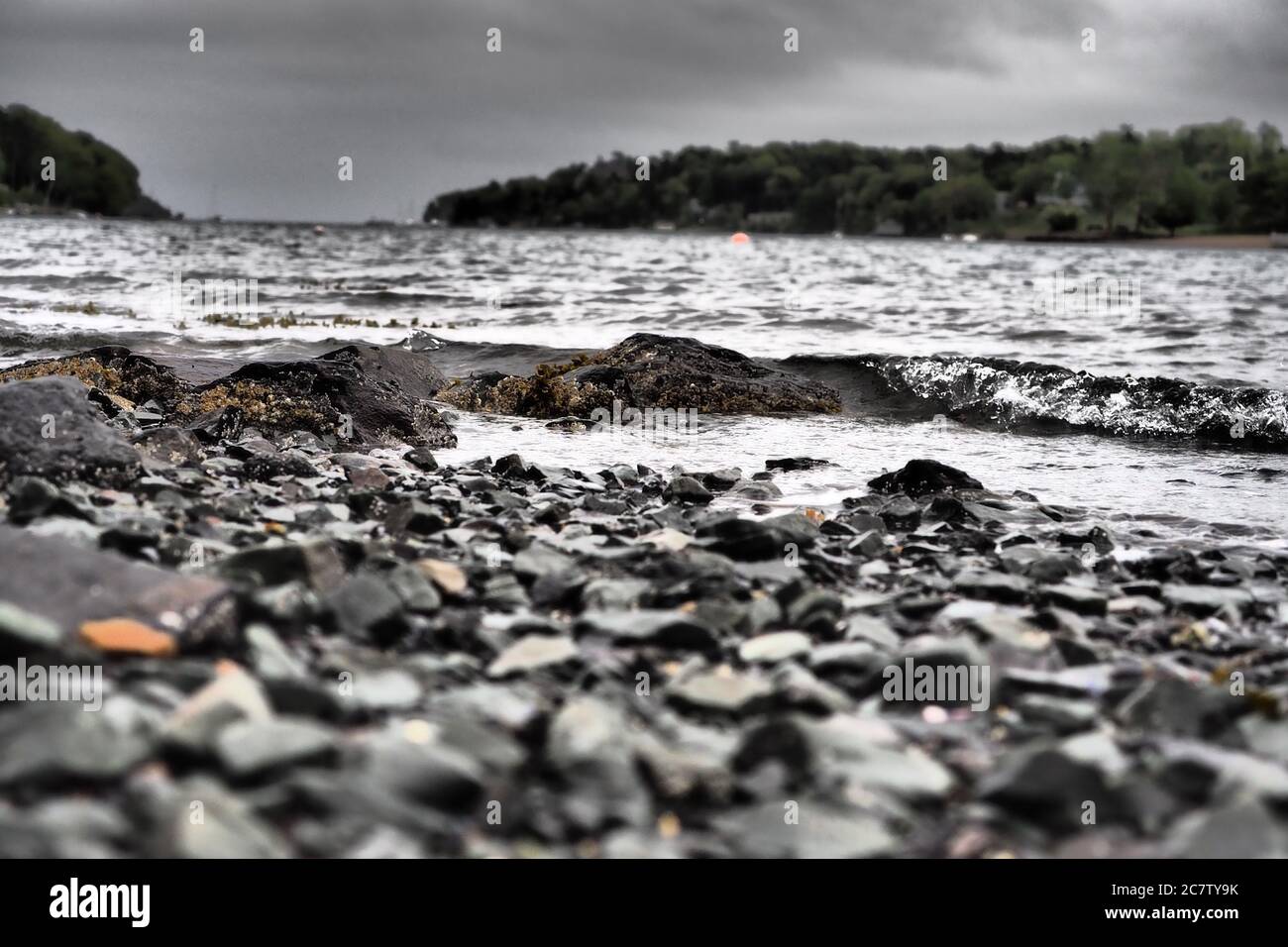 Lakeshore with pebbles and a dark sky over it in Halifax, Canada Stock ...