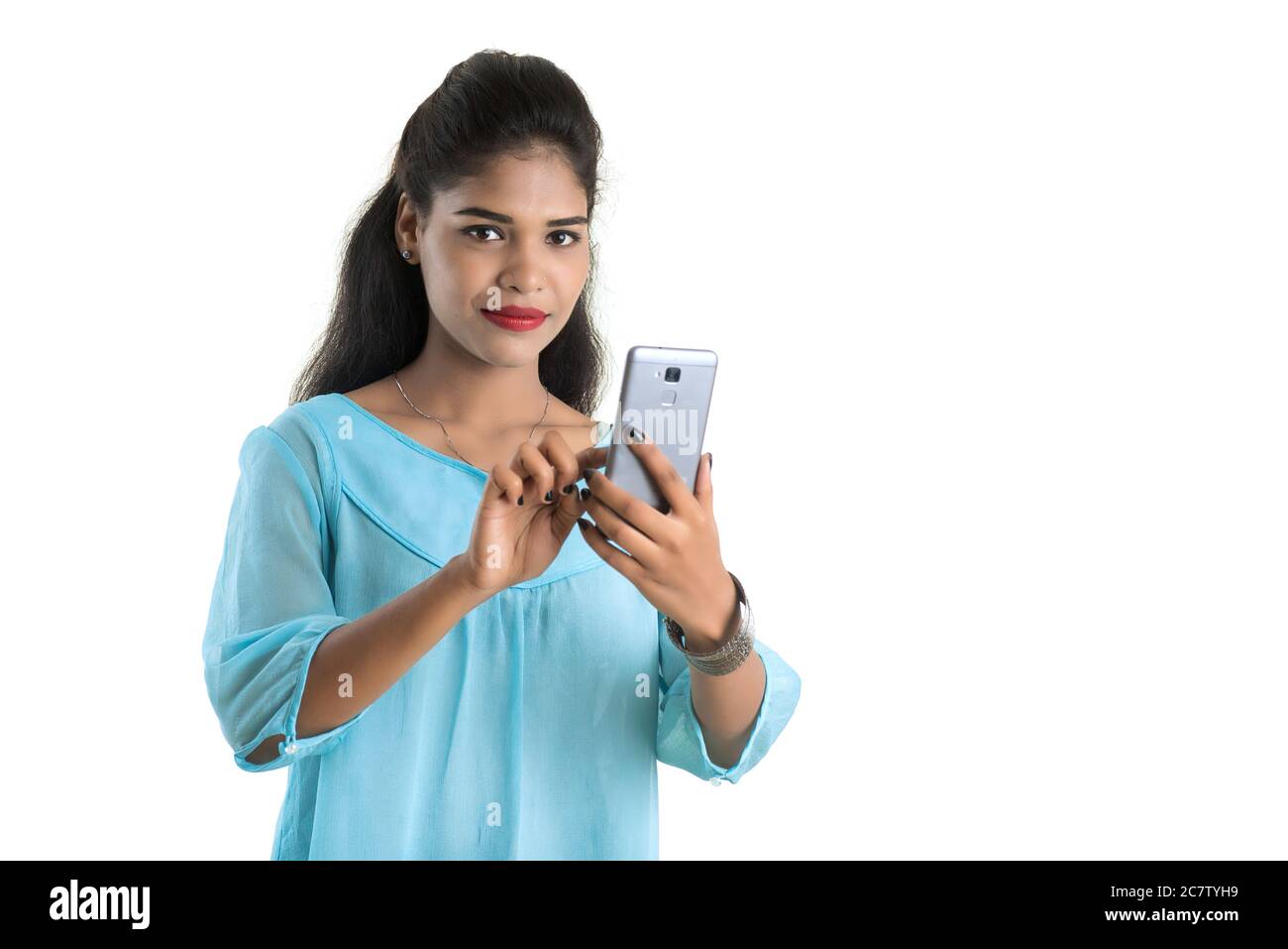 Young Indian girl using a mobile phone or smartphone isolated on a ...