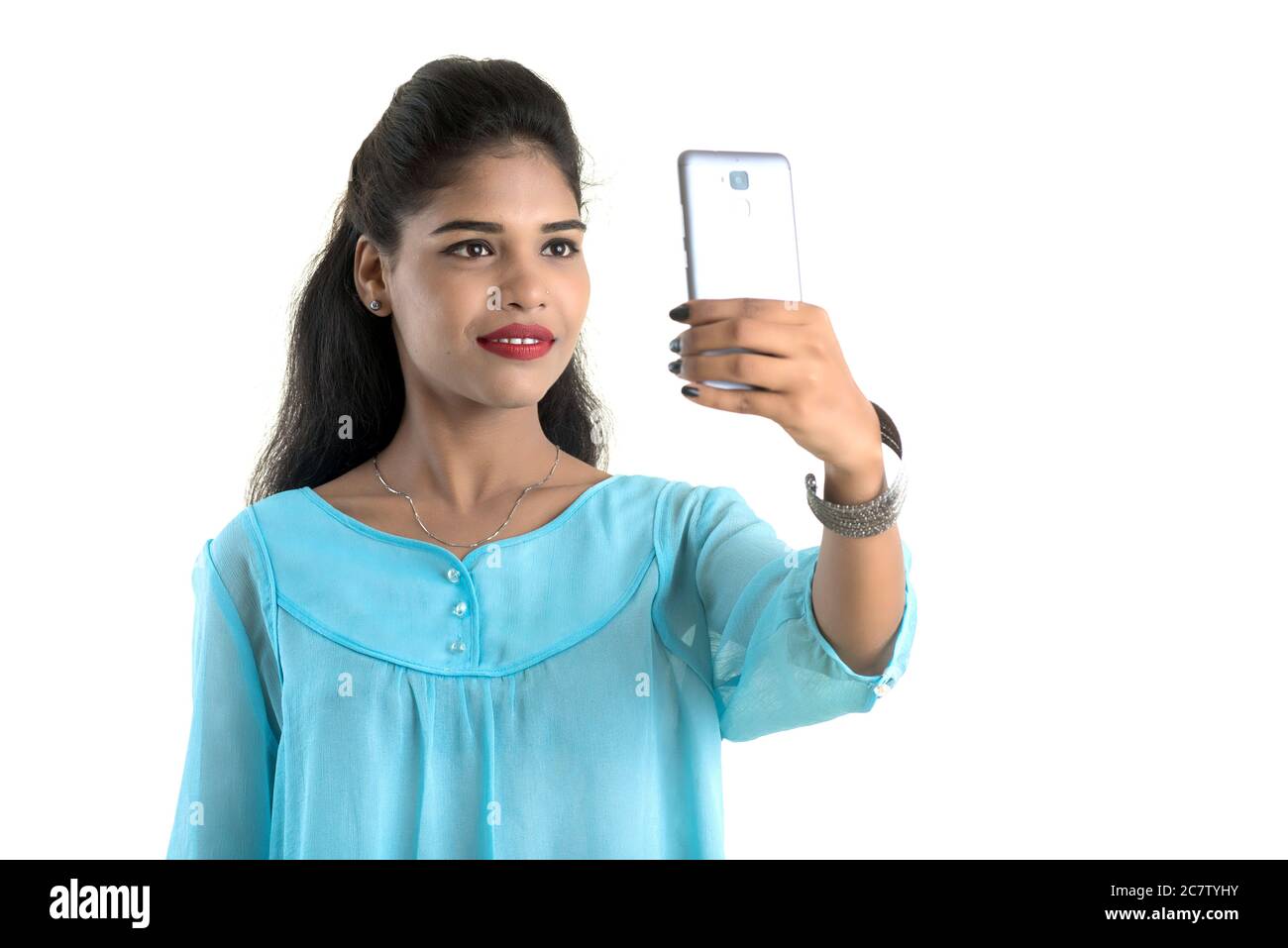Young Indian girl using a mobile phone or smartphone isolated on a ...
