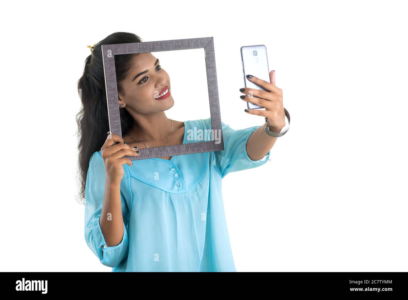 Young Indian girl using a mobile phone or smartphone with photo frame ...