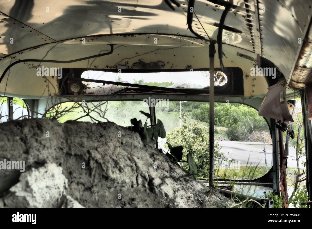 Inside view of an old abandoned wrecked bus in a field full of rubbish ...